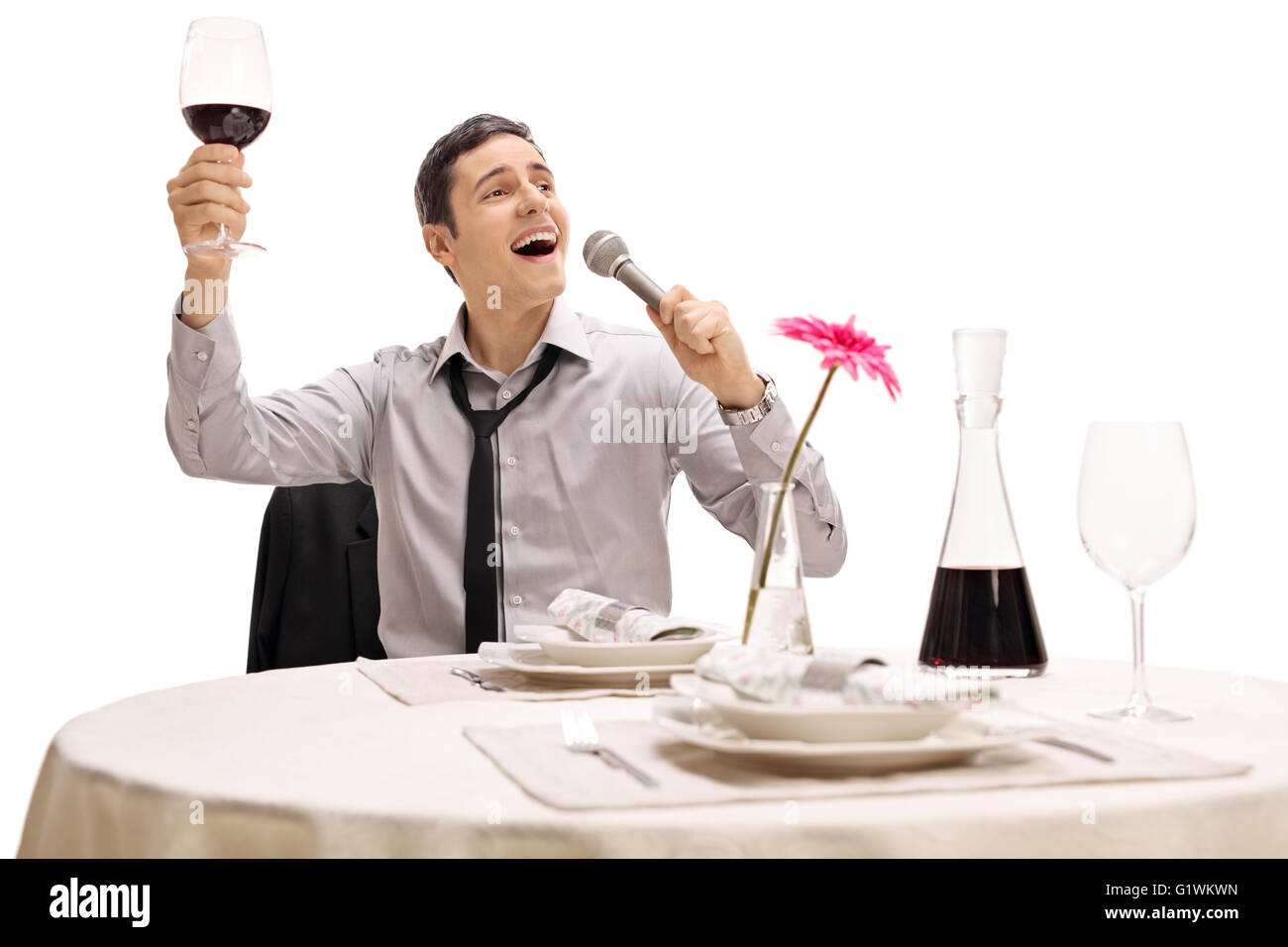 Drunk businessman holding a glass of wine and singing seated at a ...