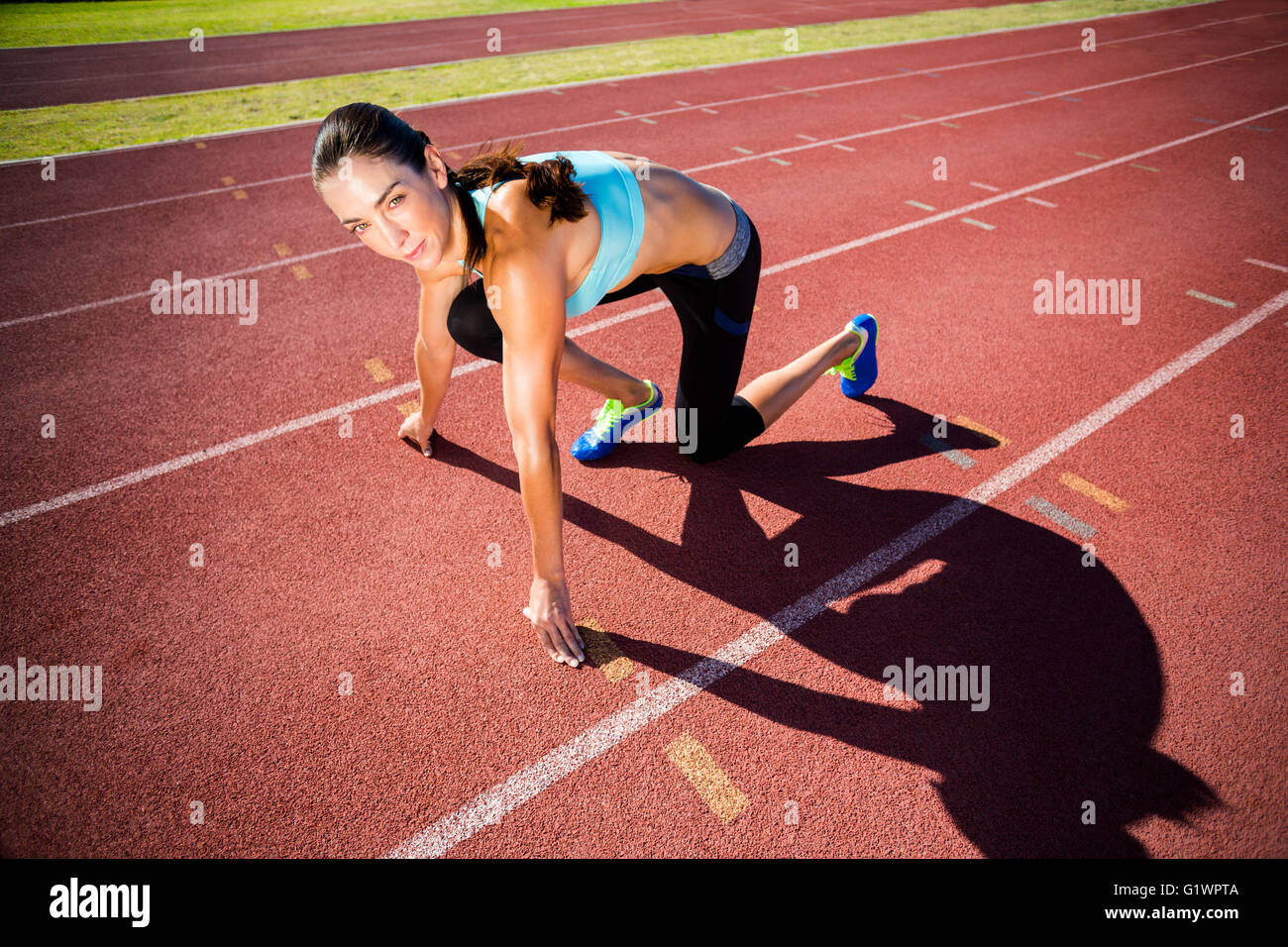 Portrait of female athlete in ready to run position Stock Photo - Alamy