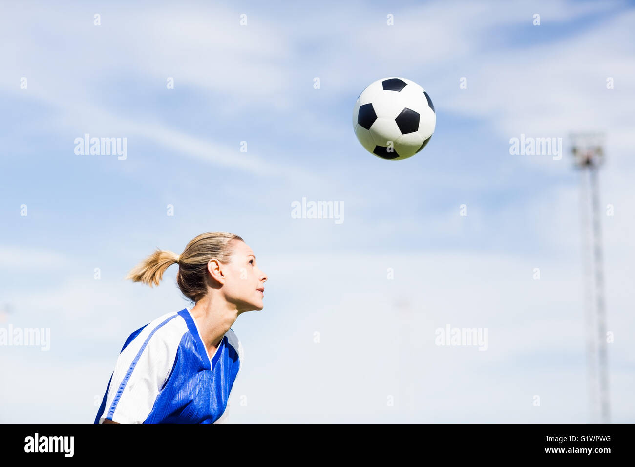Female football player playing football Stock Photo - Alamy