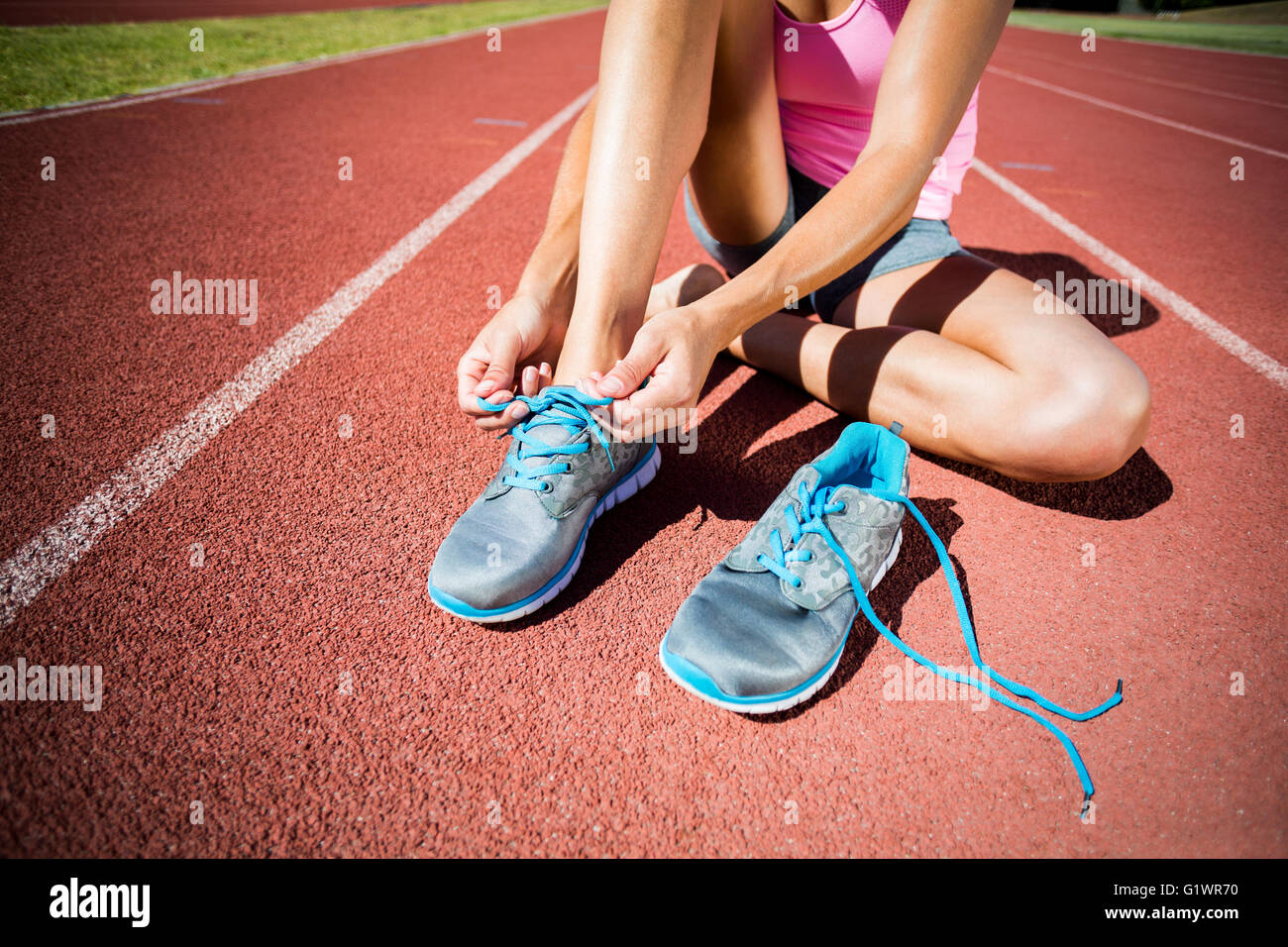 Female athlete tying her running shoes Stock Photo - Alamy