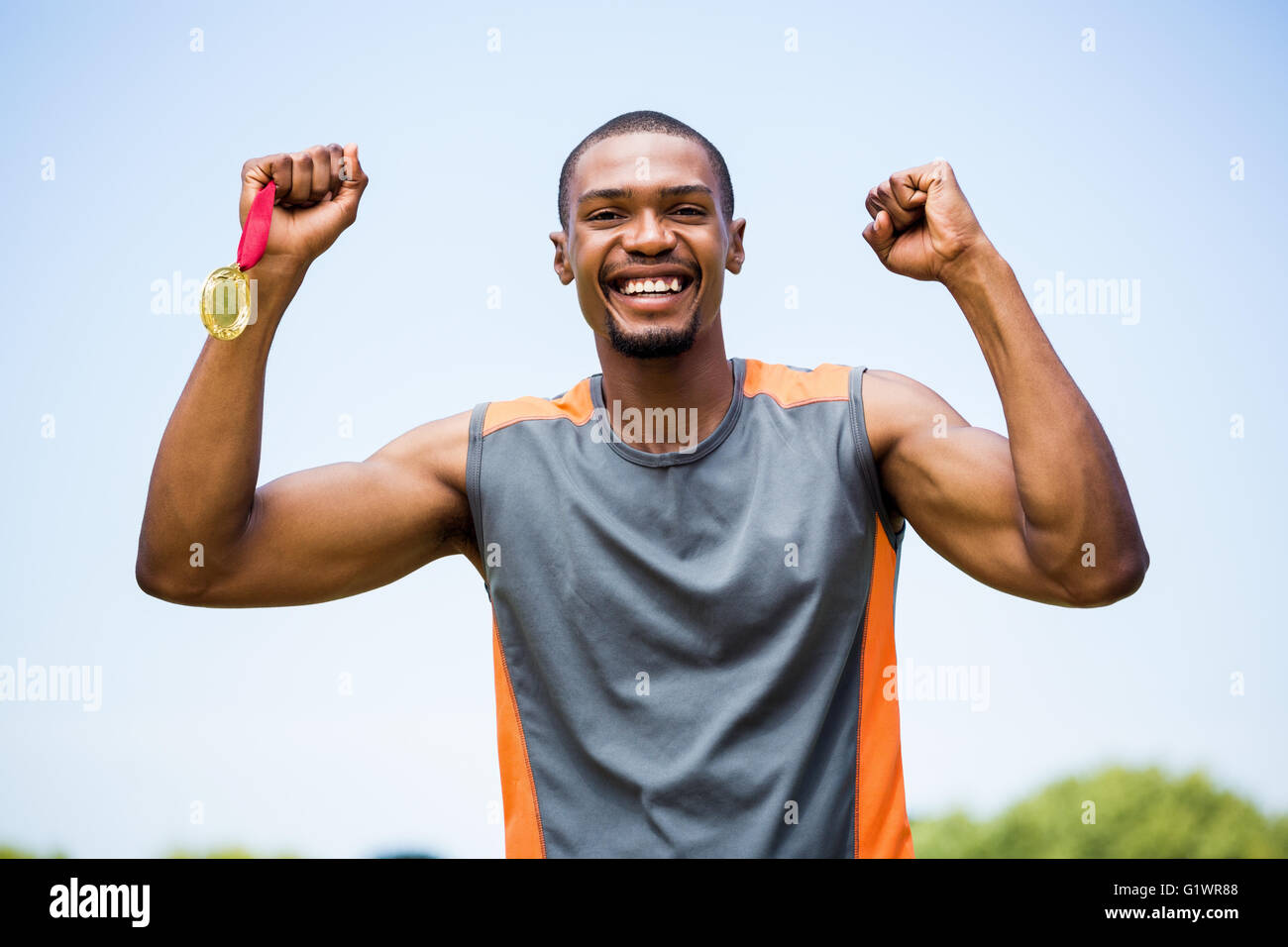 Athlete cheering with gold medal Stock Photo - Alamy