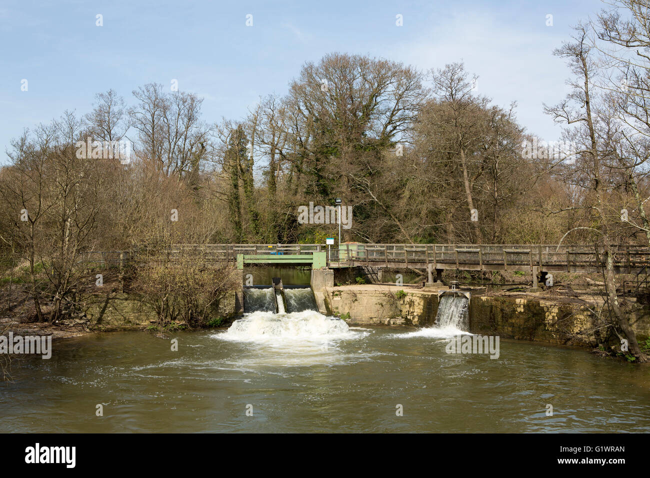 Wier with water flowing through two sluice gates into a pond Stock ...