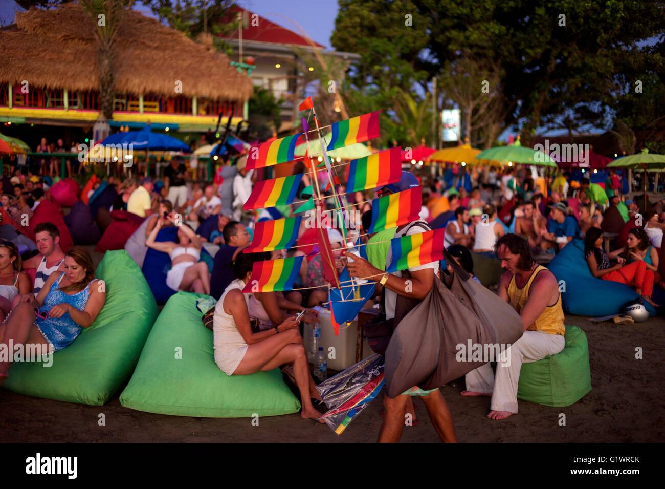 Tourists enjoying Kuta beach on the tropical island of Bali in ...