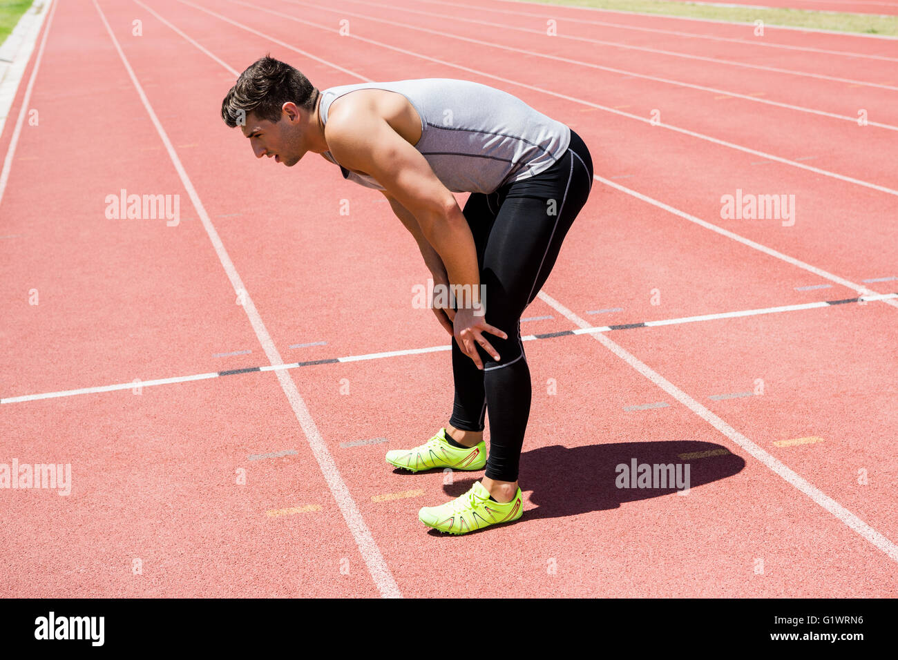 Tired athlete standing on running track Stock Photo - Alamy