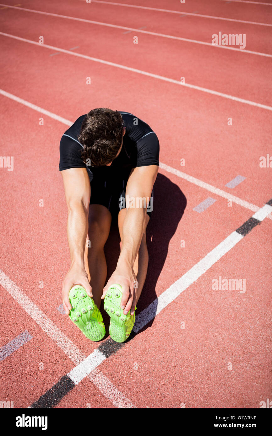 Tired athlete sitting on the running track Stock Photo - Alamy