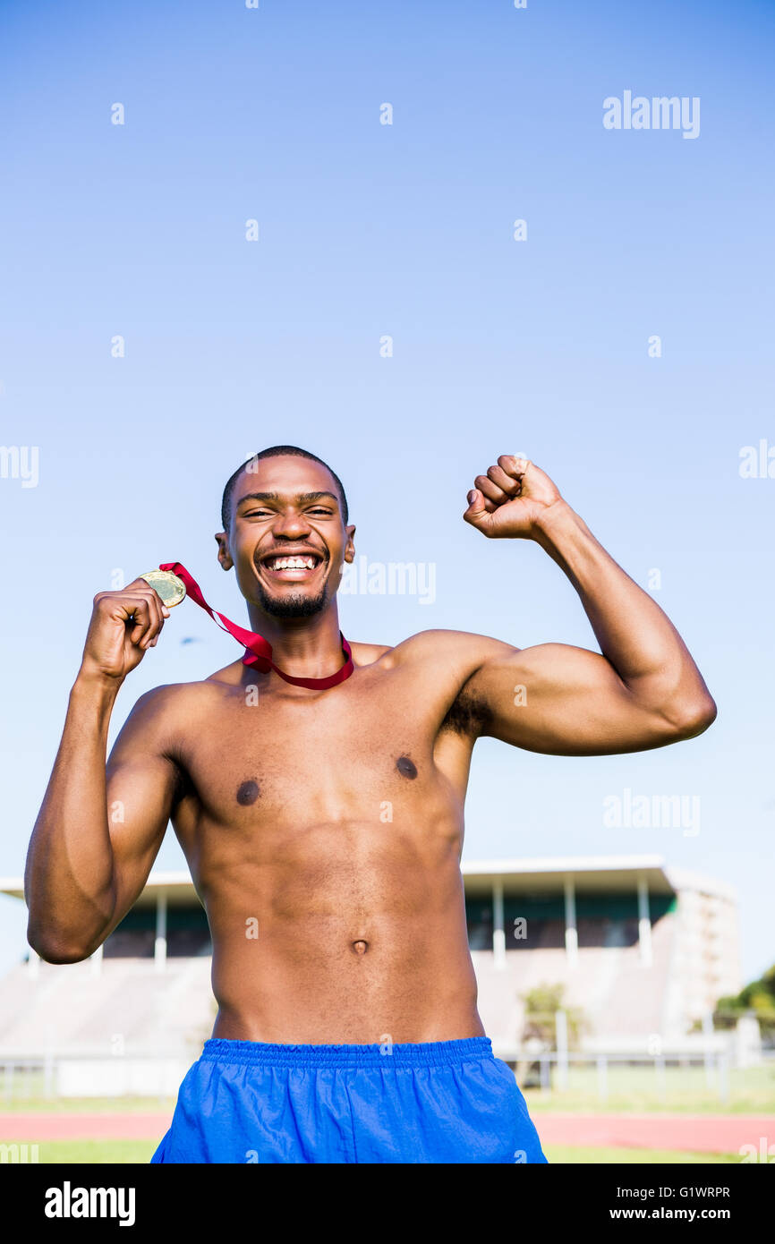 Athlete cheering with gold medal Stock Photo - Alamy