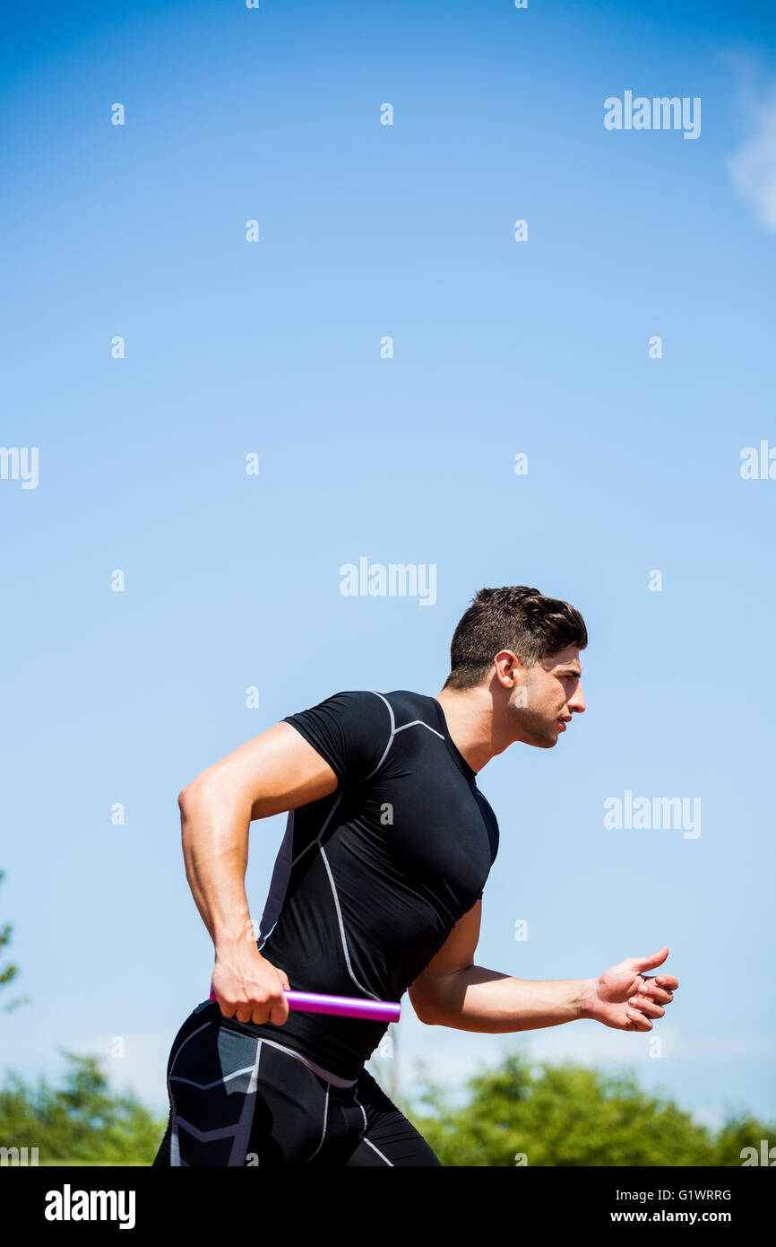 Relay athlete running with baton Stock Photo - Alamy