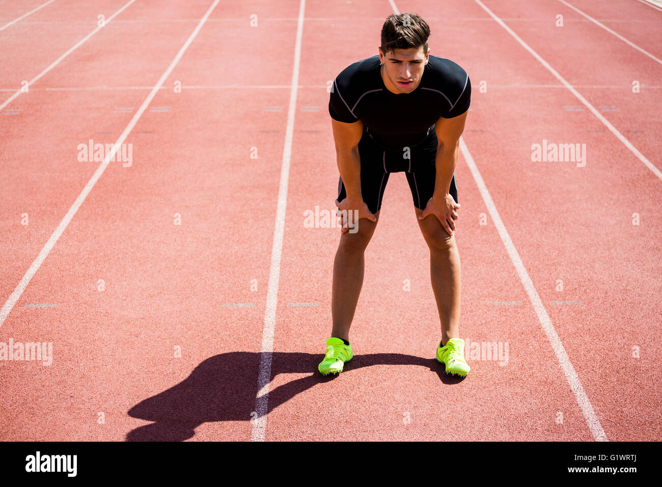 Tired athlete standing on running track Stock Photo - Alamy