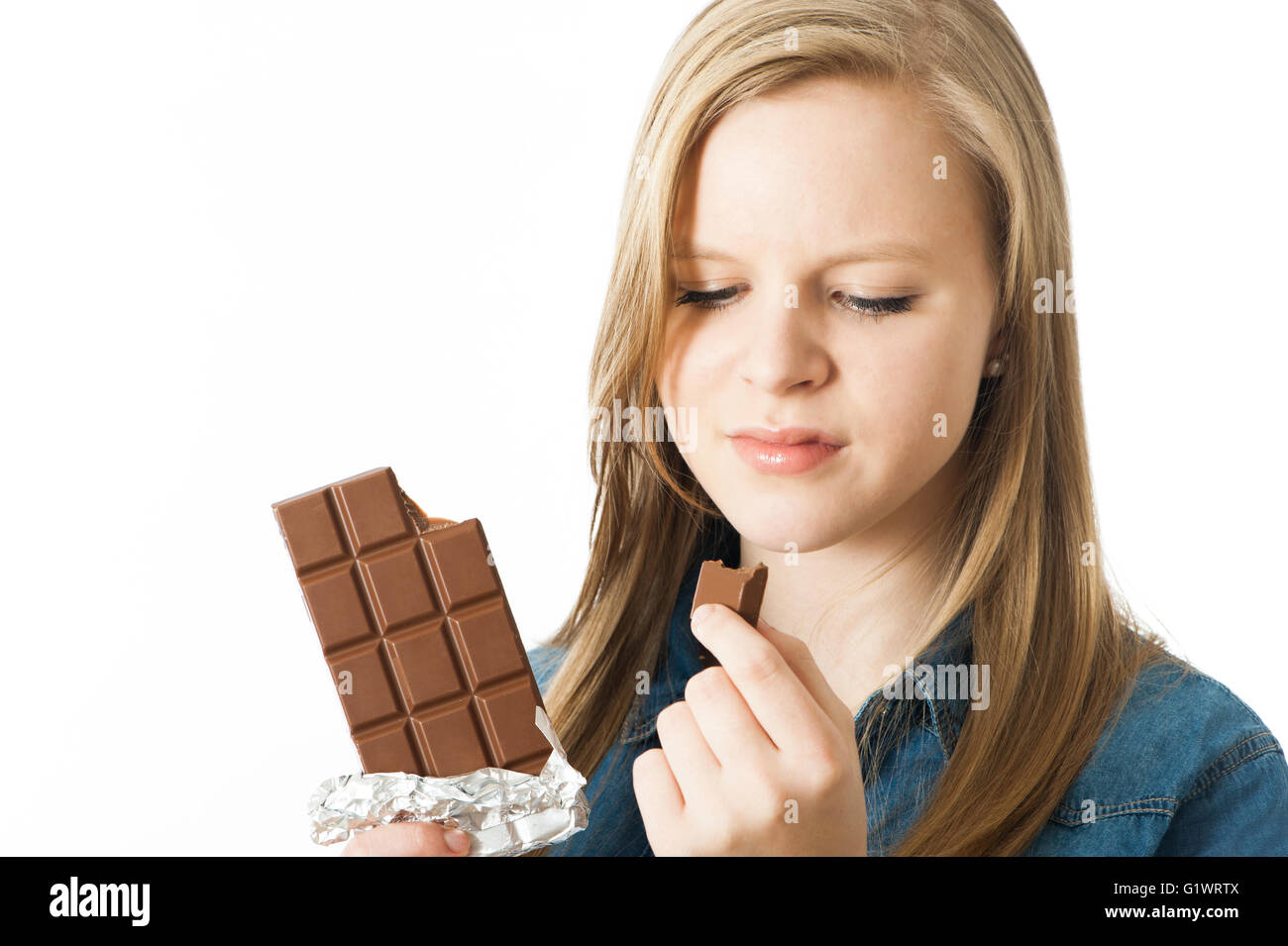Girl biting a bar of chocolate Stock Photo - Alamy