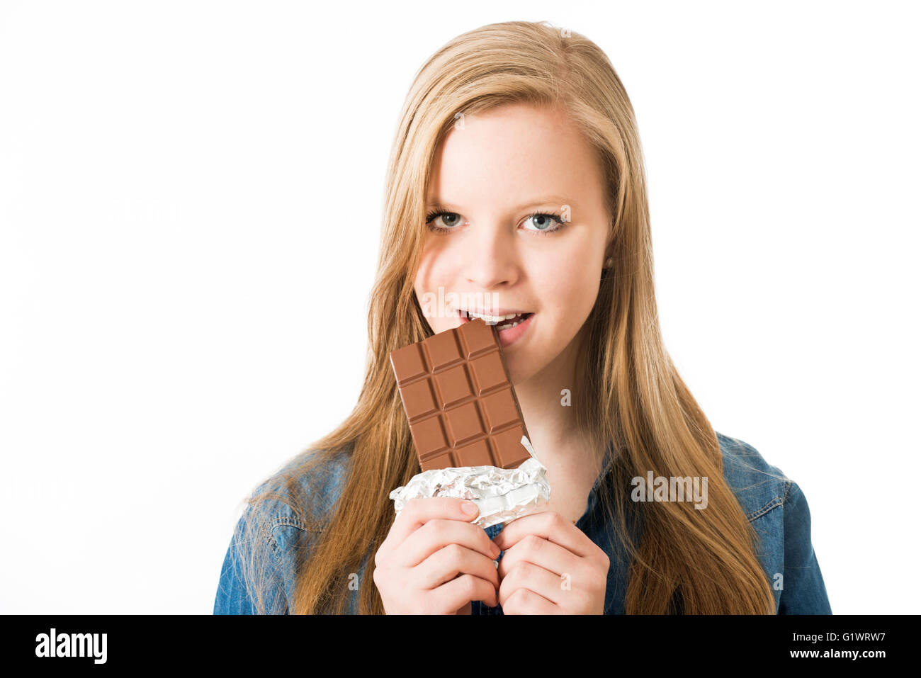 Girl biting a bar of chocolate Stock Photo - Alamy