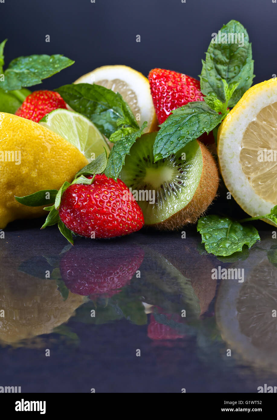 The ripe juicy fruits and peppermint leaves on a dark background Stock ...