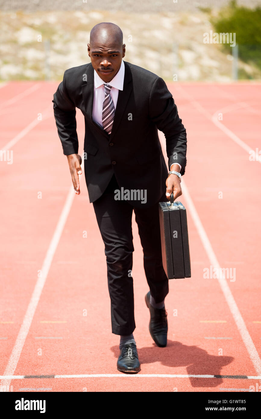Businessman running on a running track Stock Photo - Alamy