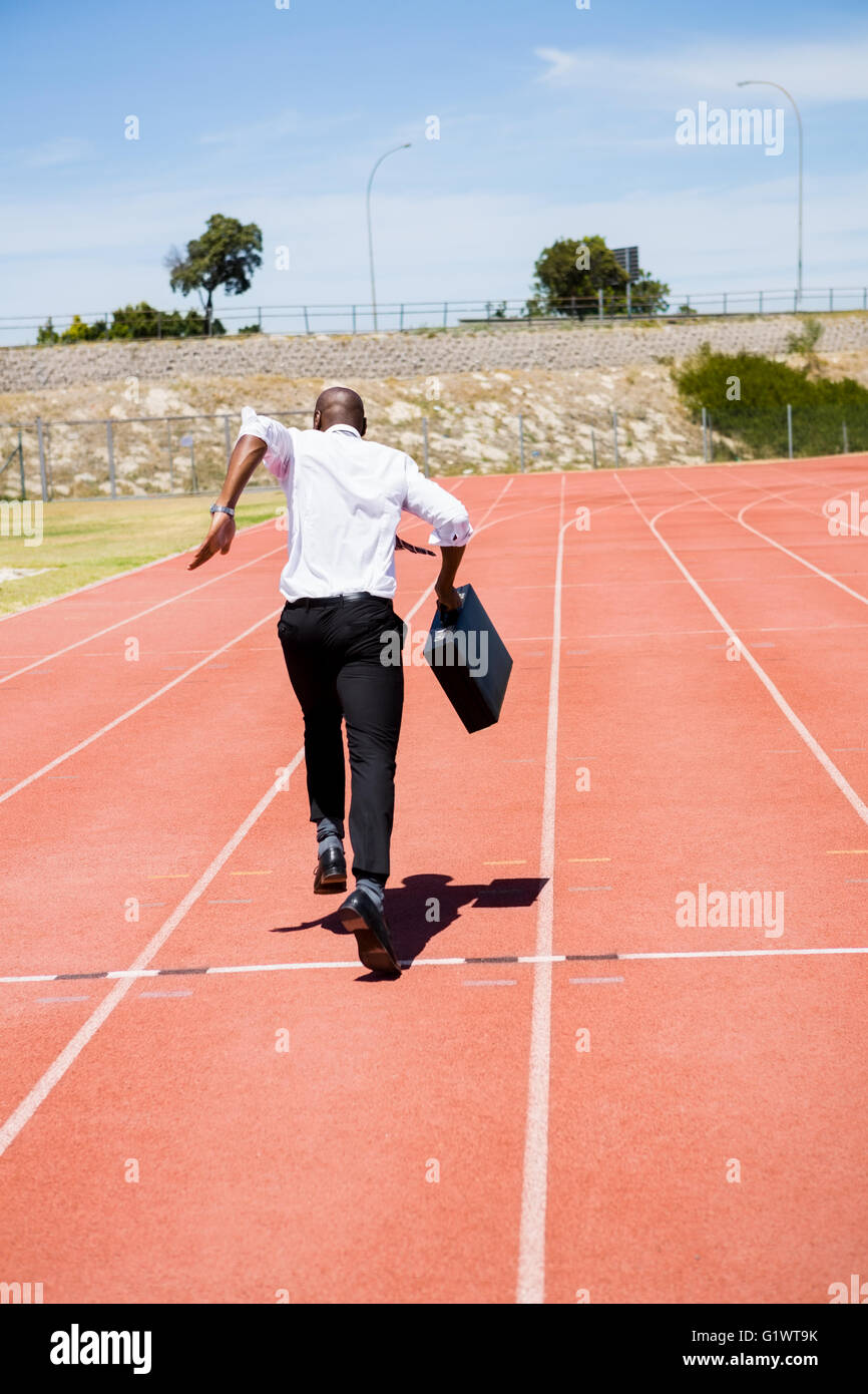 Businessman running on a running track Stock Photo - Alamy