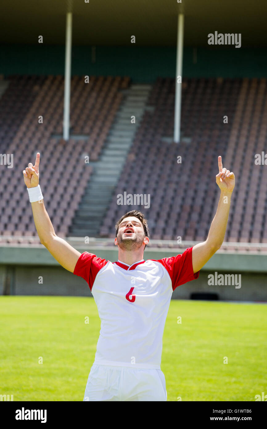 Excited football player with hands raised Stock Photo - Alamy