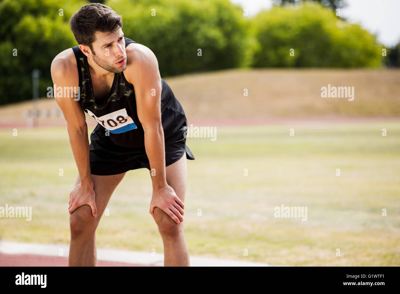 Tired athlete standing on running track Stock Photo - Alamy