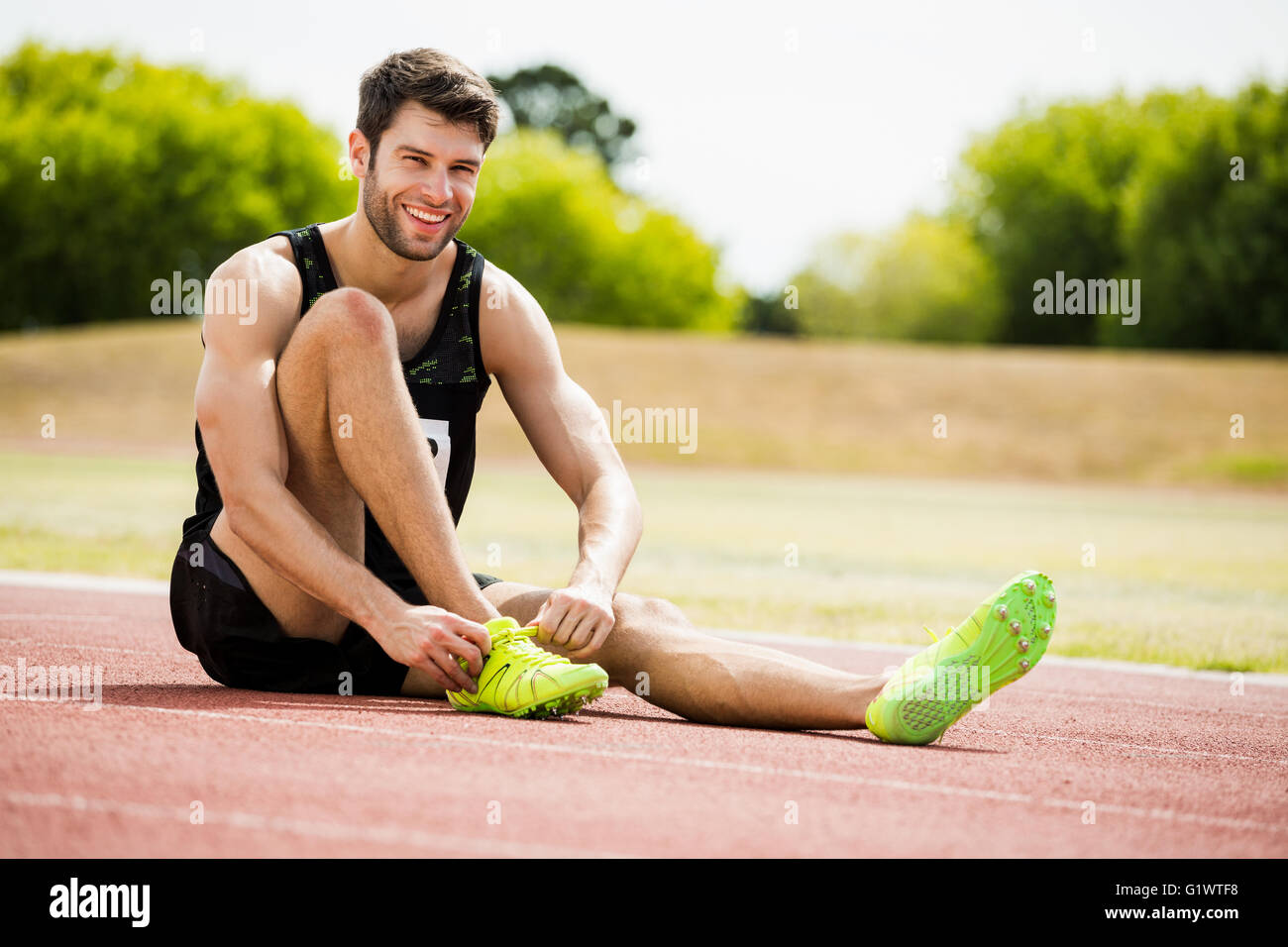 Athlete tying his shoe laces on running track Stock Photo - Alamy