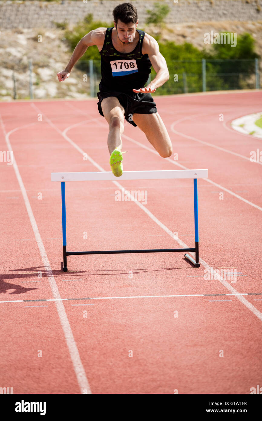 Athlete jumping above the hurdle Stock Photo - Alamy
