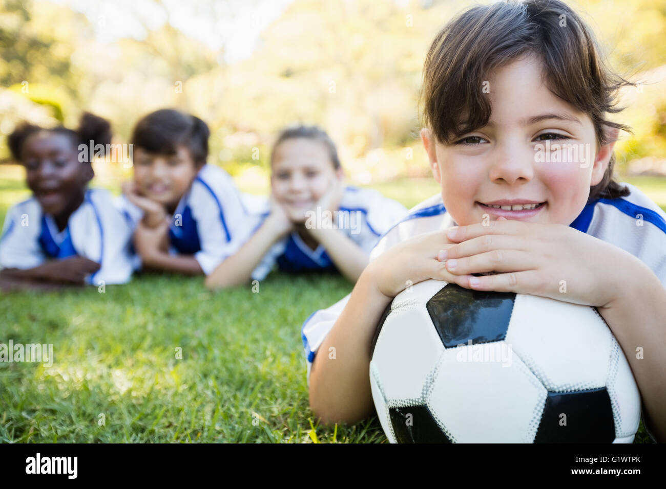 Close Up View Of Girl Lying On The Floor With Her Soccer Team Stock