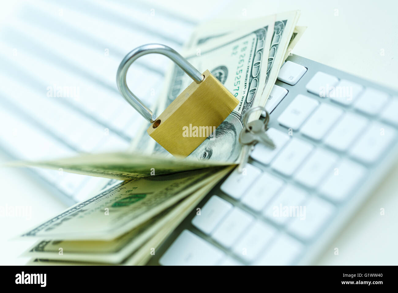 Security lock on dollar bills with white computer keyboard - breach of ...