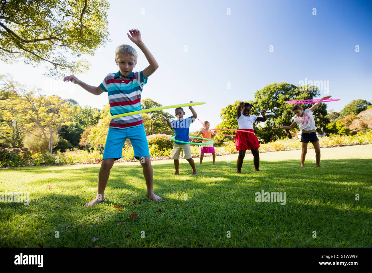 Kids playing hoop together during a sunny day Stock Photo - Alamy