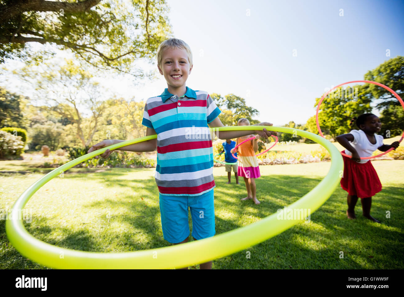 Kids playing hoop together during a sunny day Stock Photo - Alamy