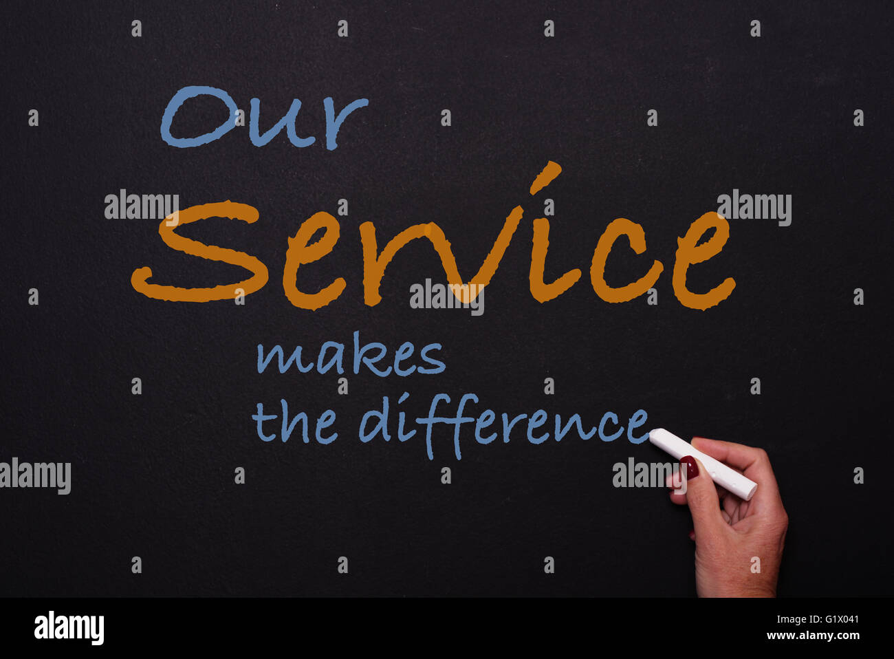 woman writes on blackboard our service makes the difference Stock Photo ...
