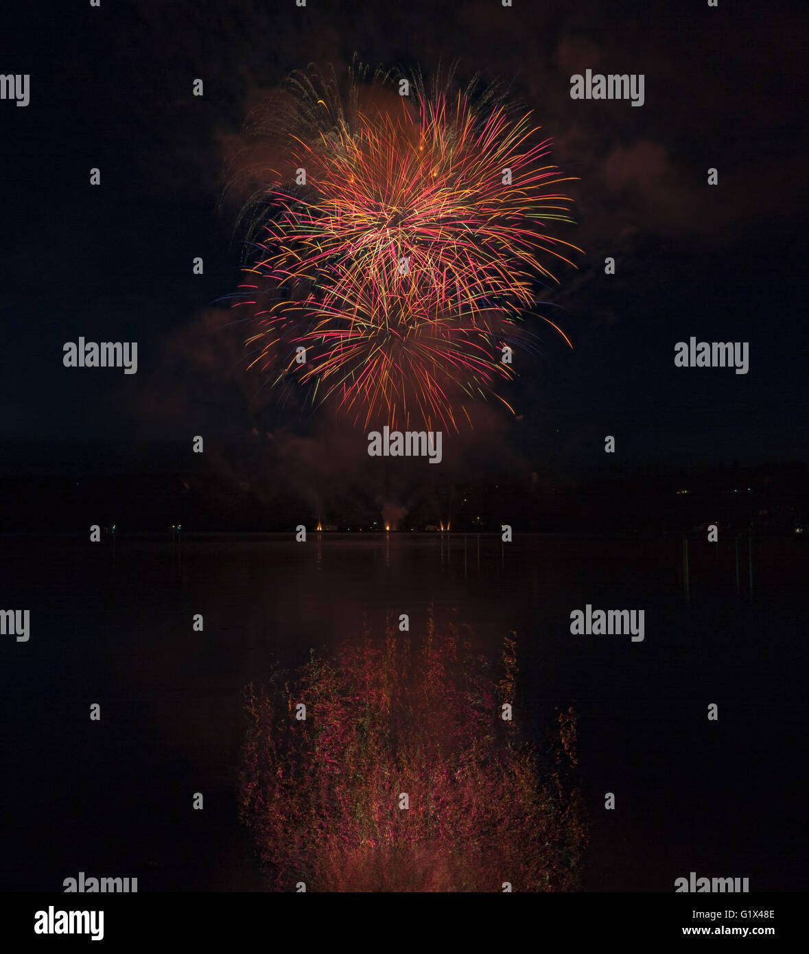 Colorful fireworks with reflection on lake and night sky in background ...