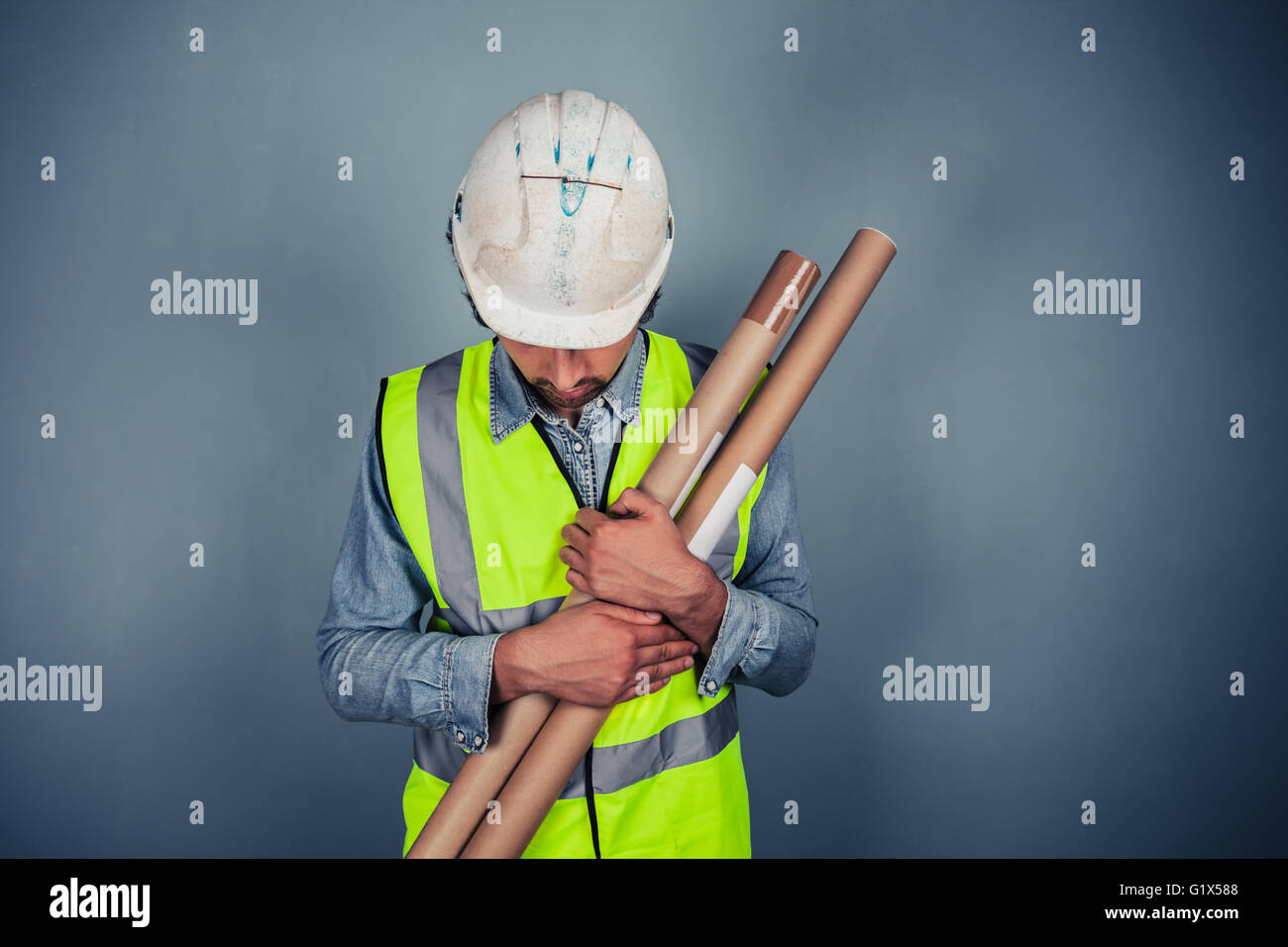 An engineer is holding a bunch of building plans Stock Photo - Alamy