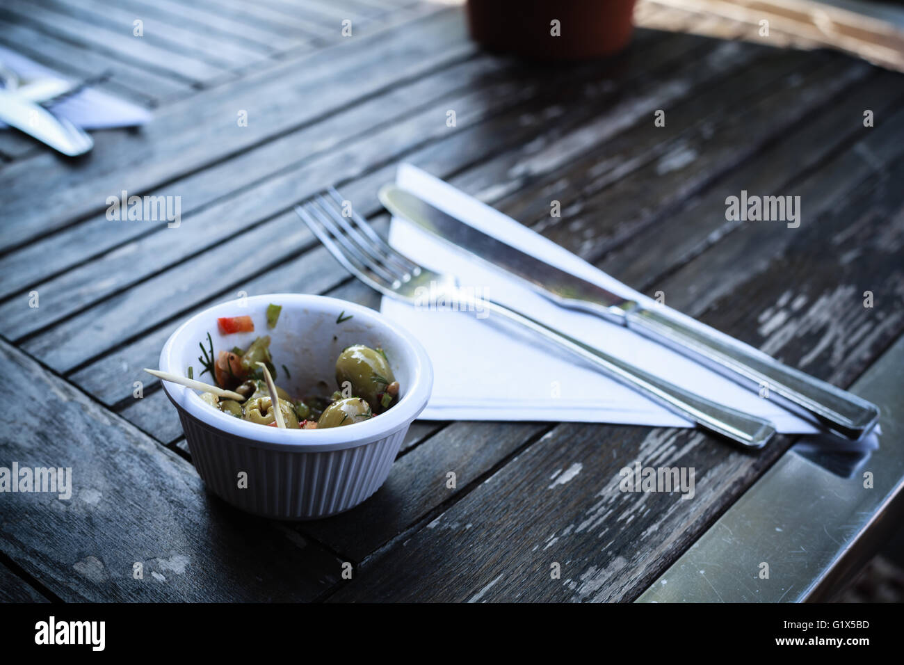 A small bowl of olives on a table outside Stock Photo - Alamy