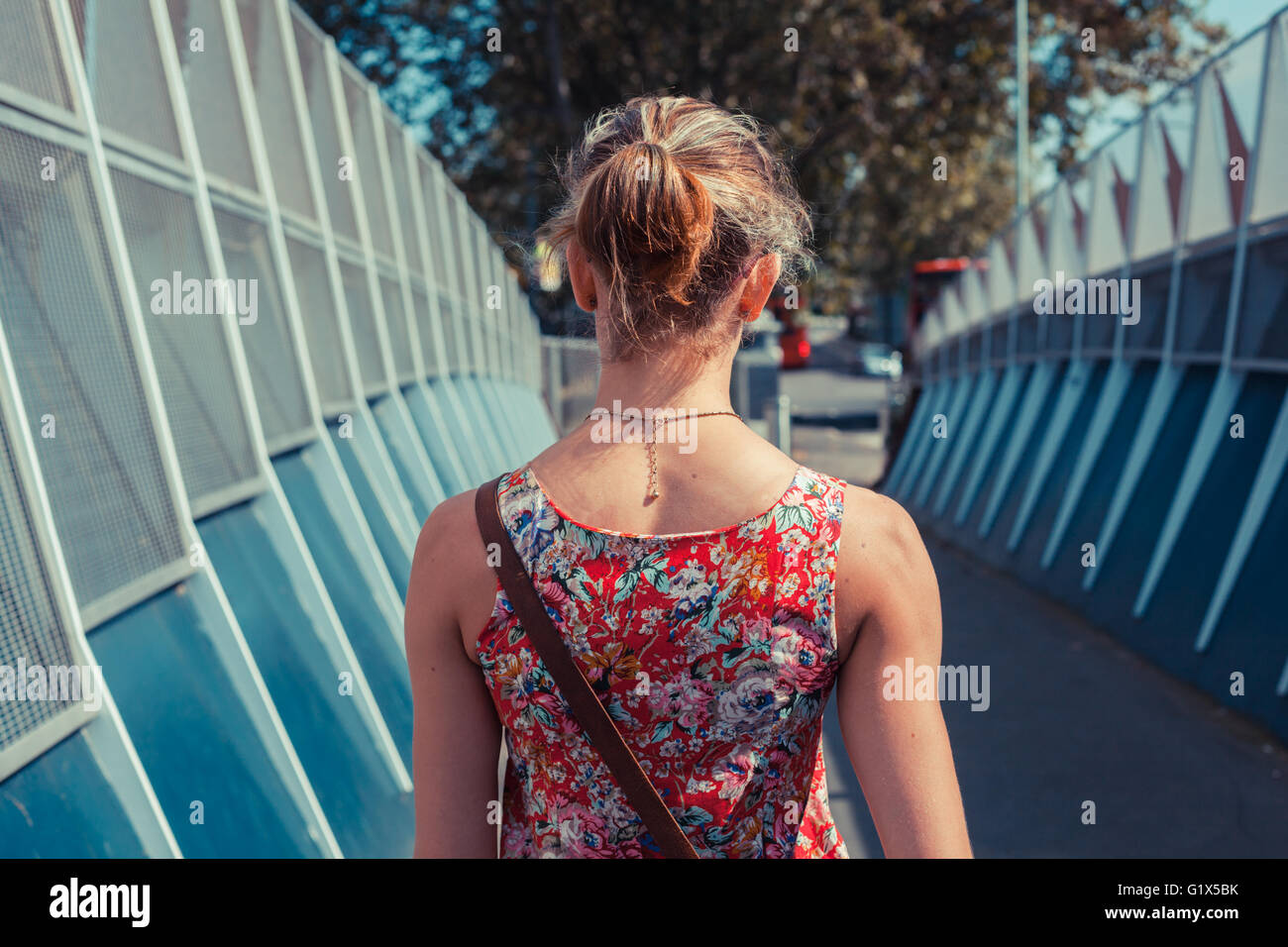 A young woman is walking in the street on a summer's day Stock Photo ...