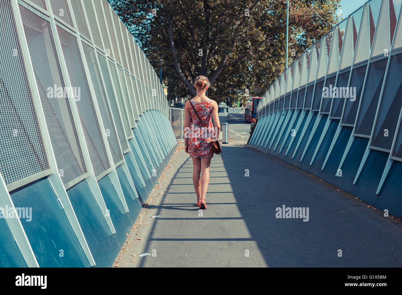 A young woman is walking in the street on a summer's day Stock Photo ...