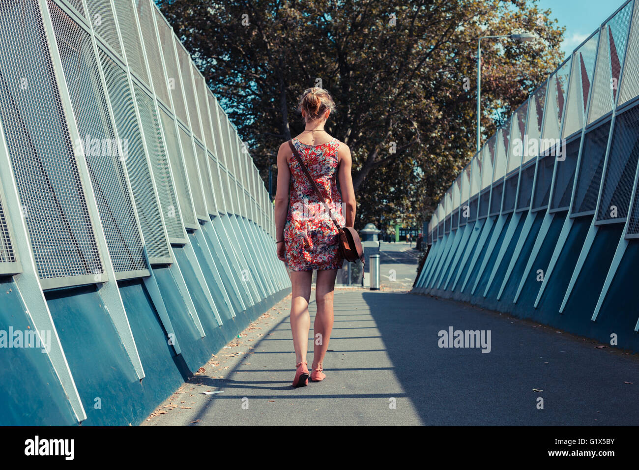 A young woman is walking in the street on a summer's day Stock Photo ...