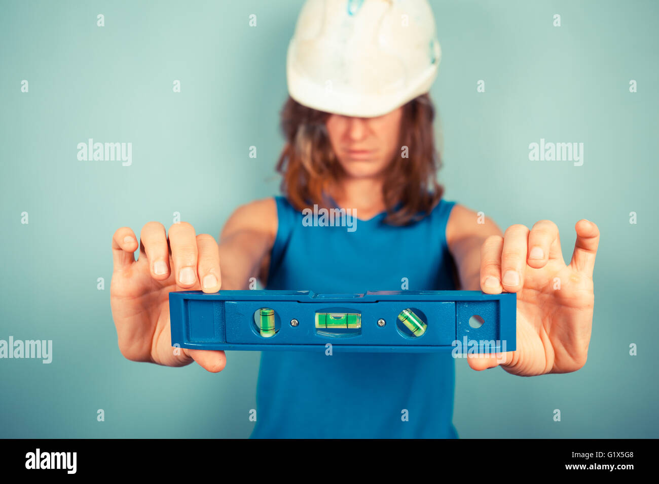A young female buidler is holding a level Stock Photo - Alamy