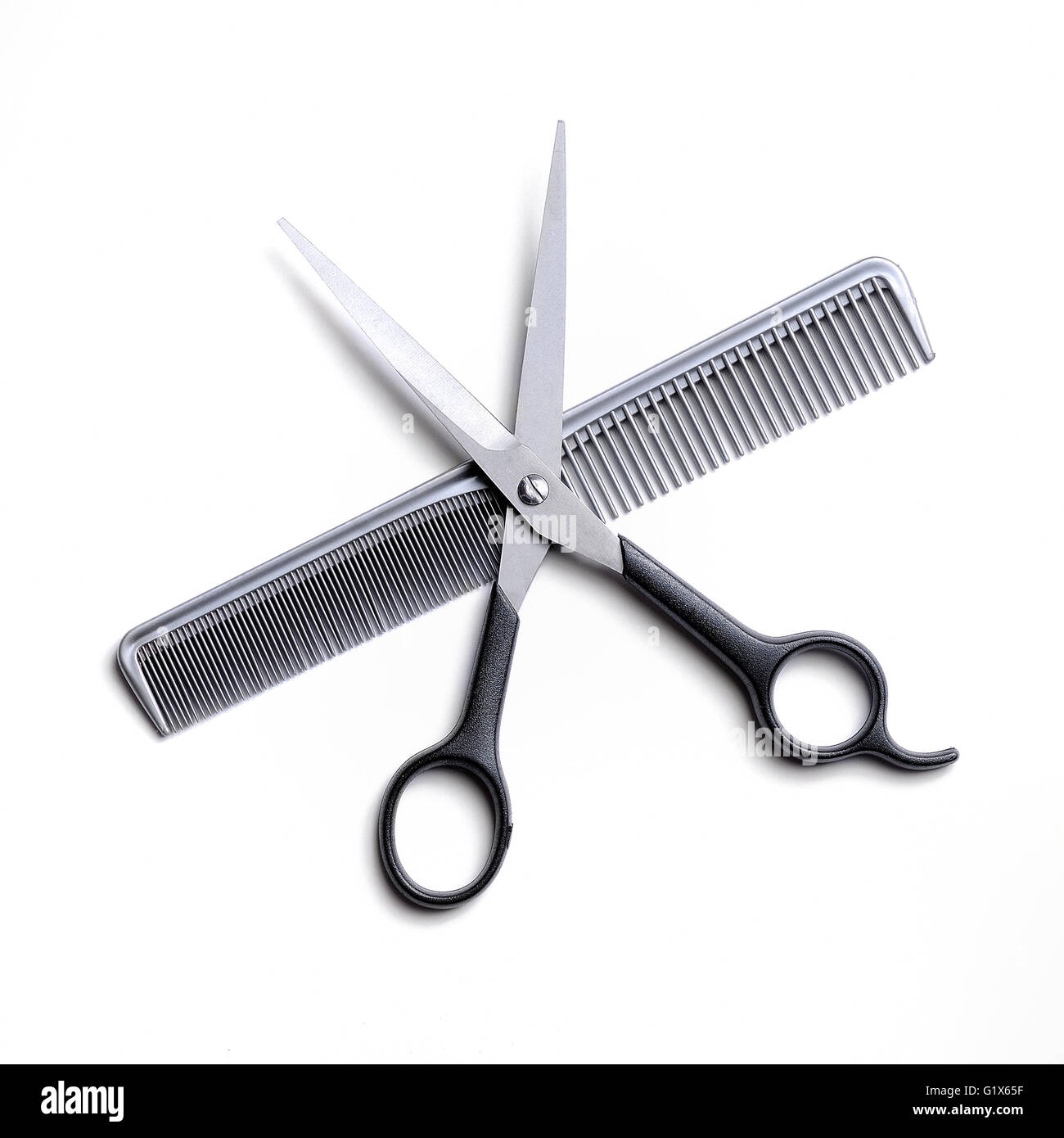 Open scissors on a gray comb barber making a cross with isolated white ...