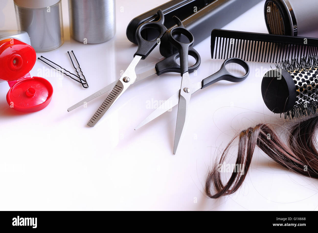 Set hairdressing articles exposed on a white table with room below left ...