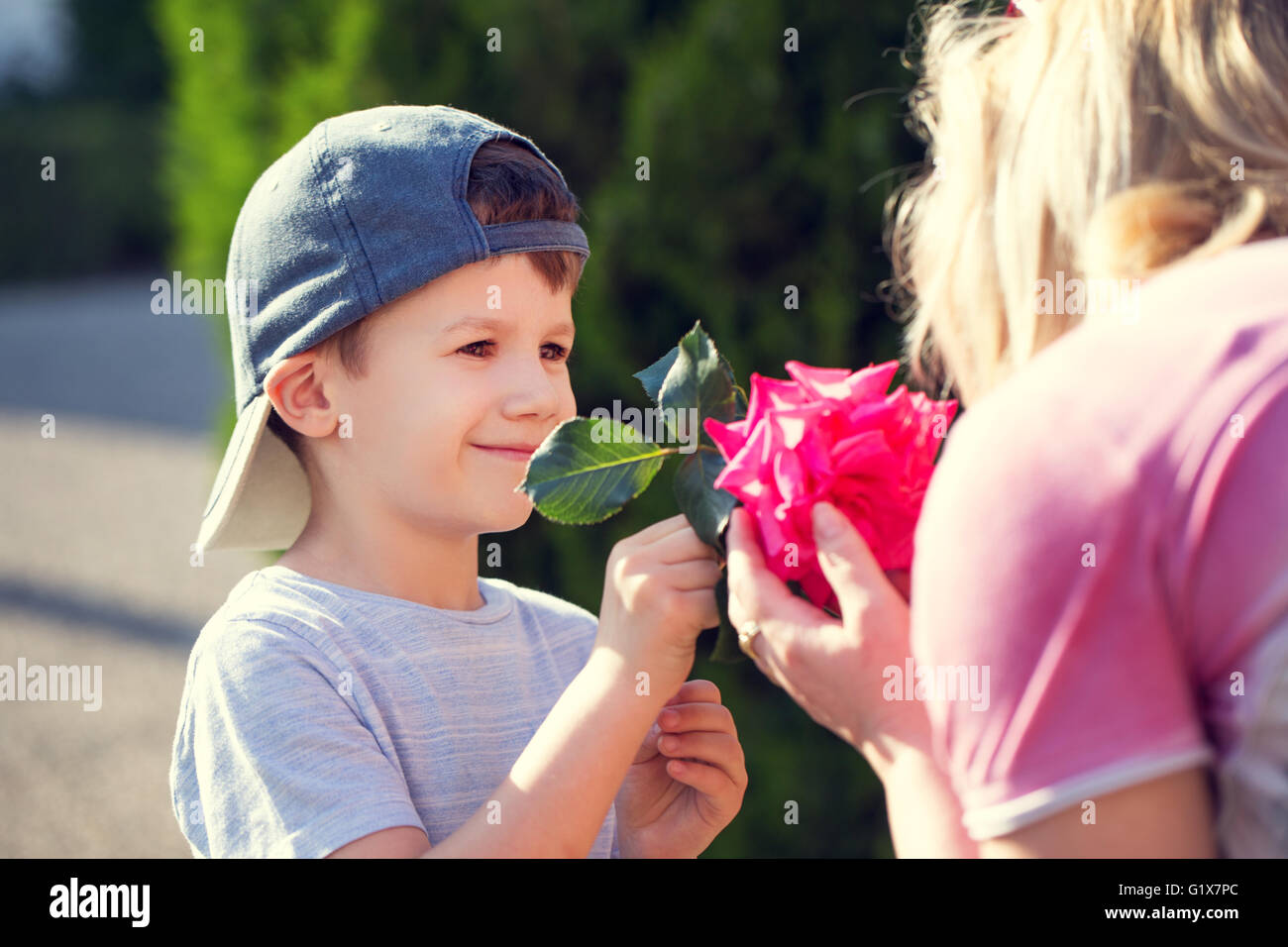 Little boy in cap give rose to mom, mother's day, outdoor Stock Photo ...