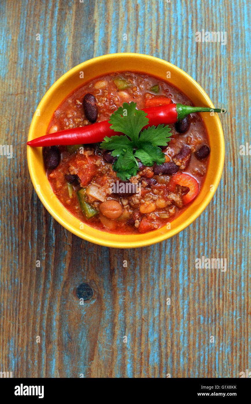Photo of a bowl of chili resting on an old wood table Stock Photo - Alamy