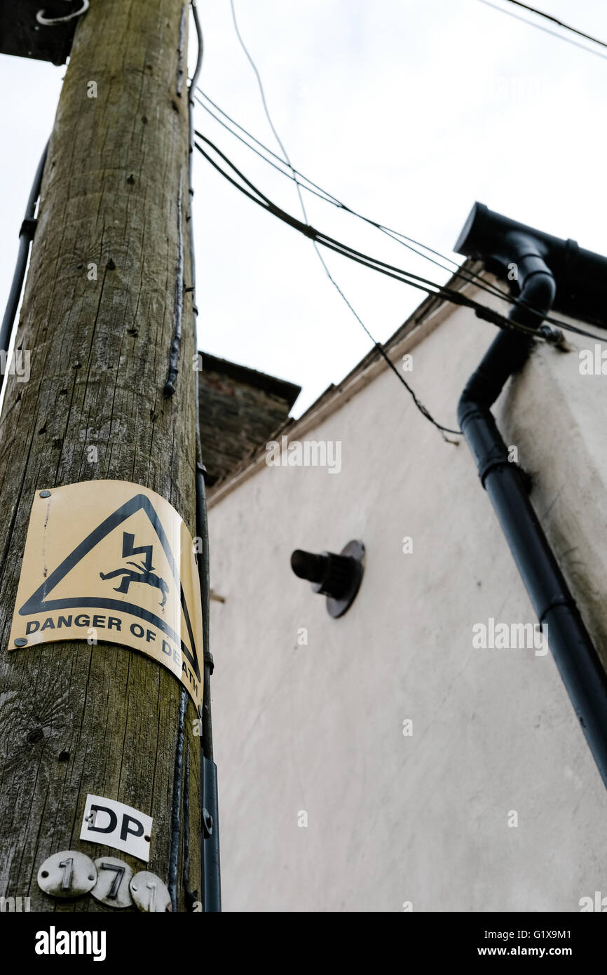 Old wooden telegraph pole seen next to a cottage showing a standard ...
