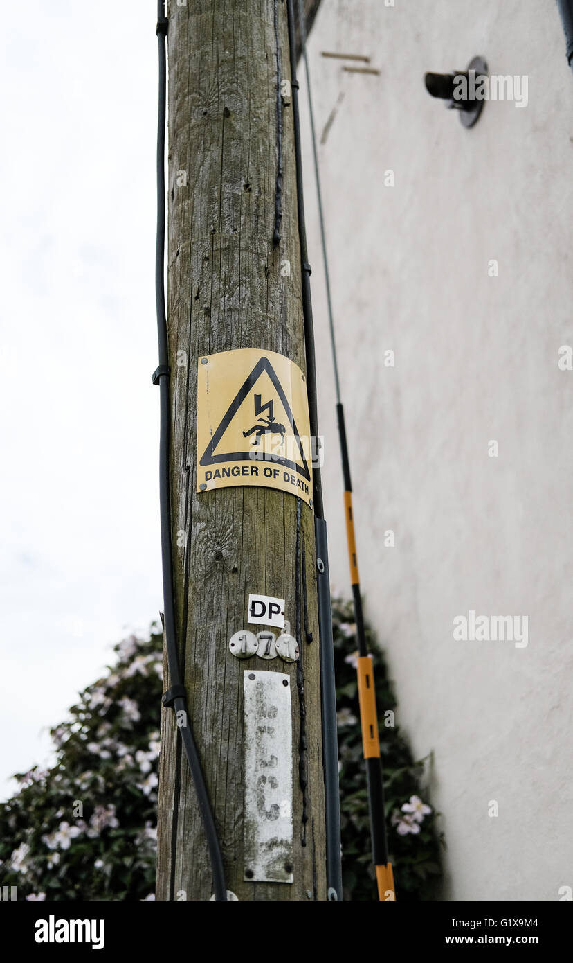 Old wooden telegraph pole seen next to a cottage showing a standard ...