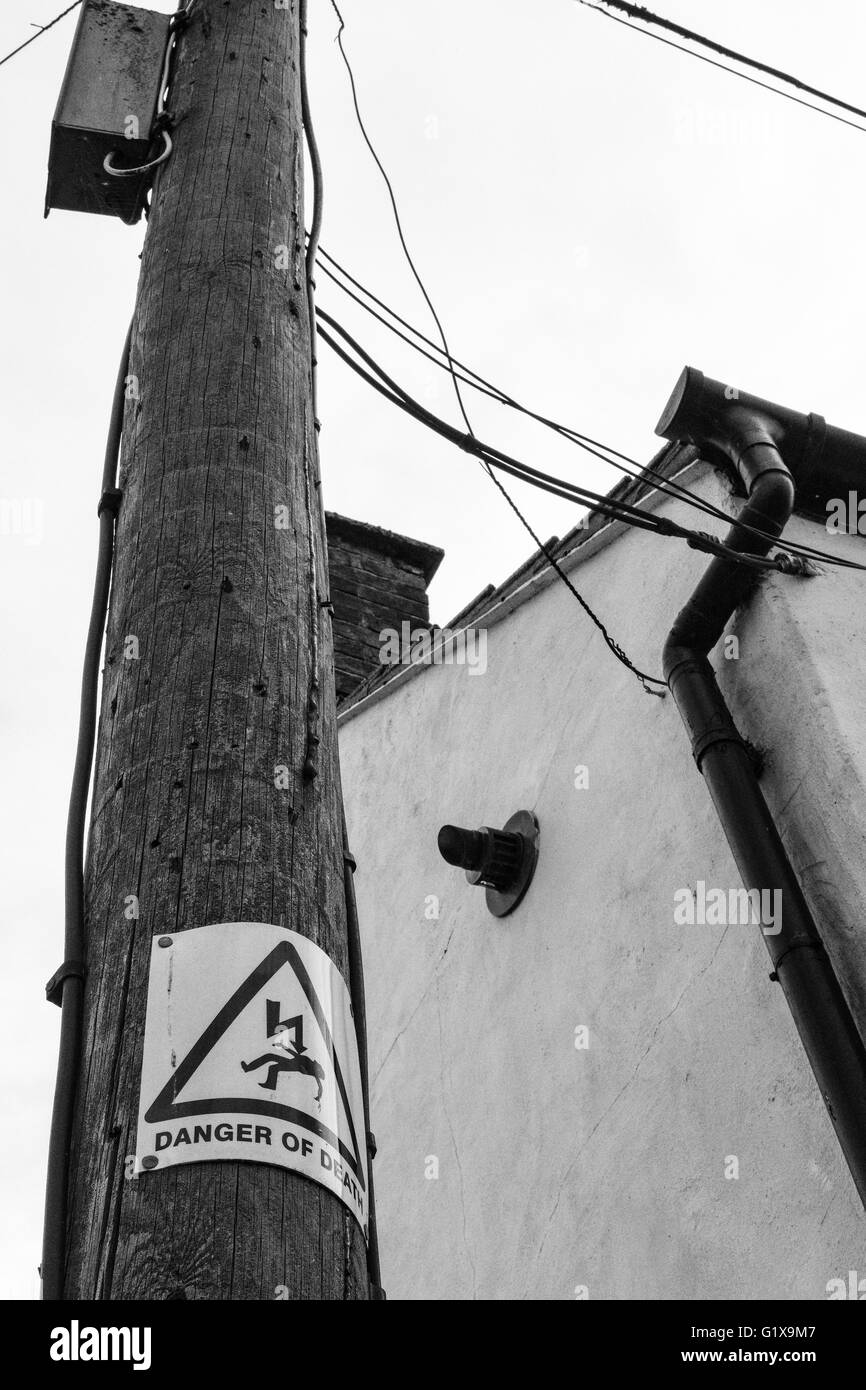 Old wooden telegraph pole seen next to a cottage showing a standard ...