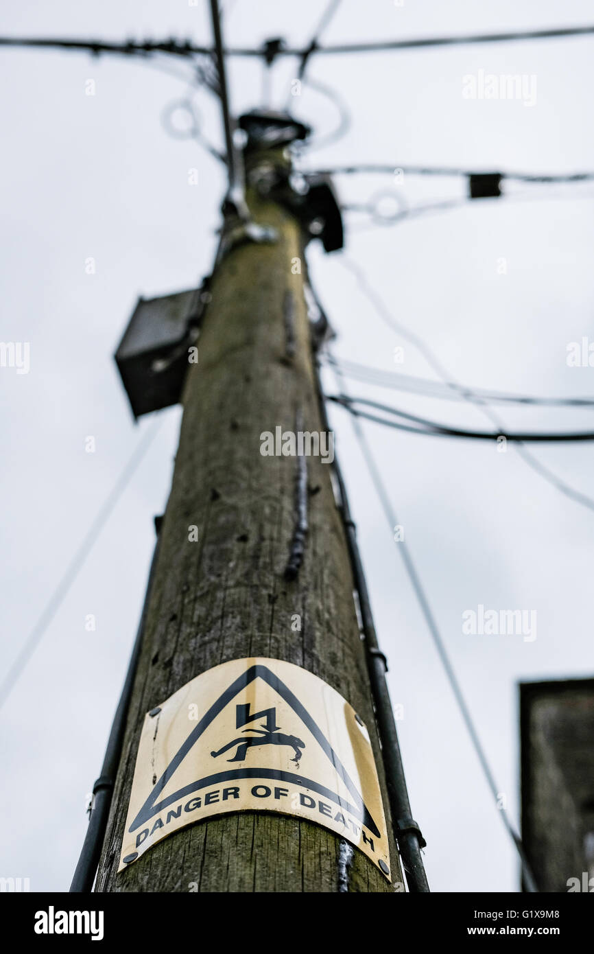Old wooden telegraph pole seen next to a cottage showing a standard ...