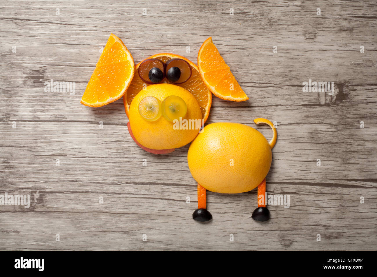 Funny pig made of orange and grape on wooden background Stock Photo - Alamy
