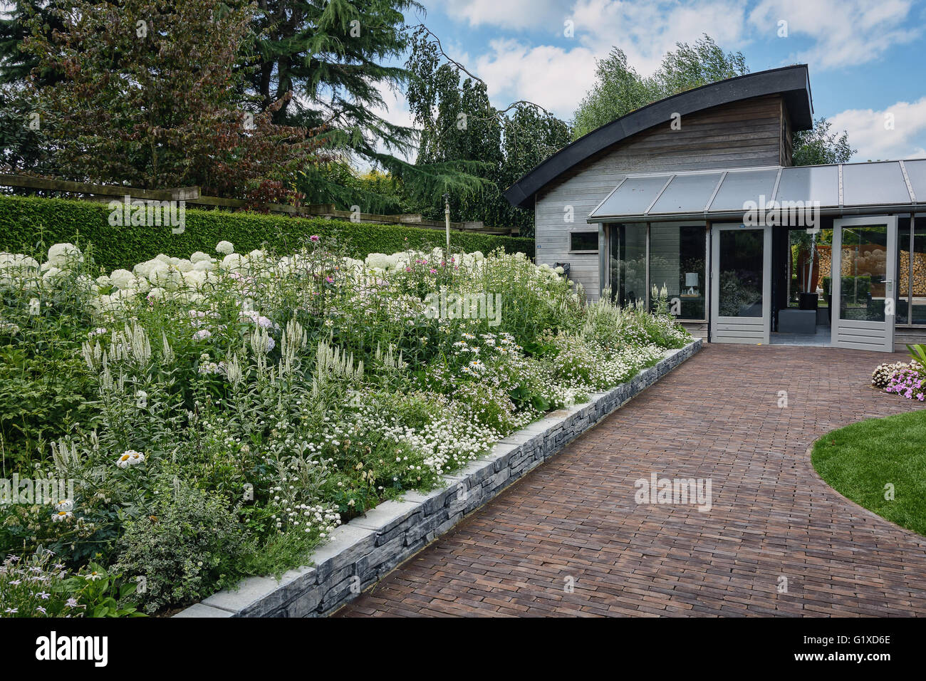 Flower curb front of the house decorated with white flowers Stock Photo ...