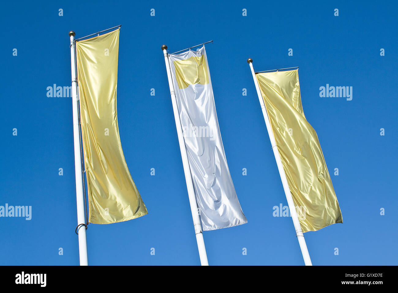 Three empty vertical banner golden flags over blue sky Stock Photo - Alamy