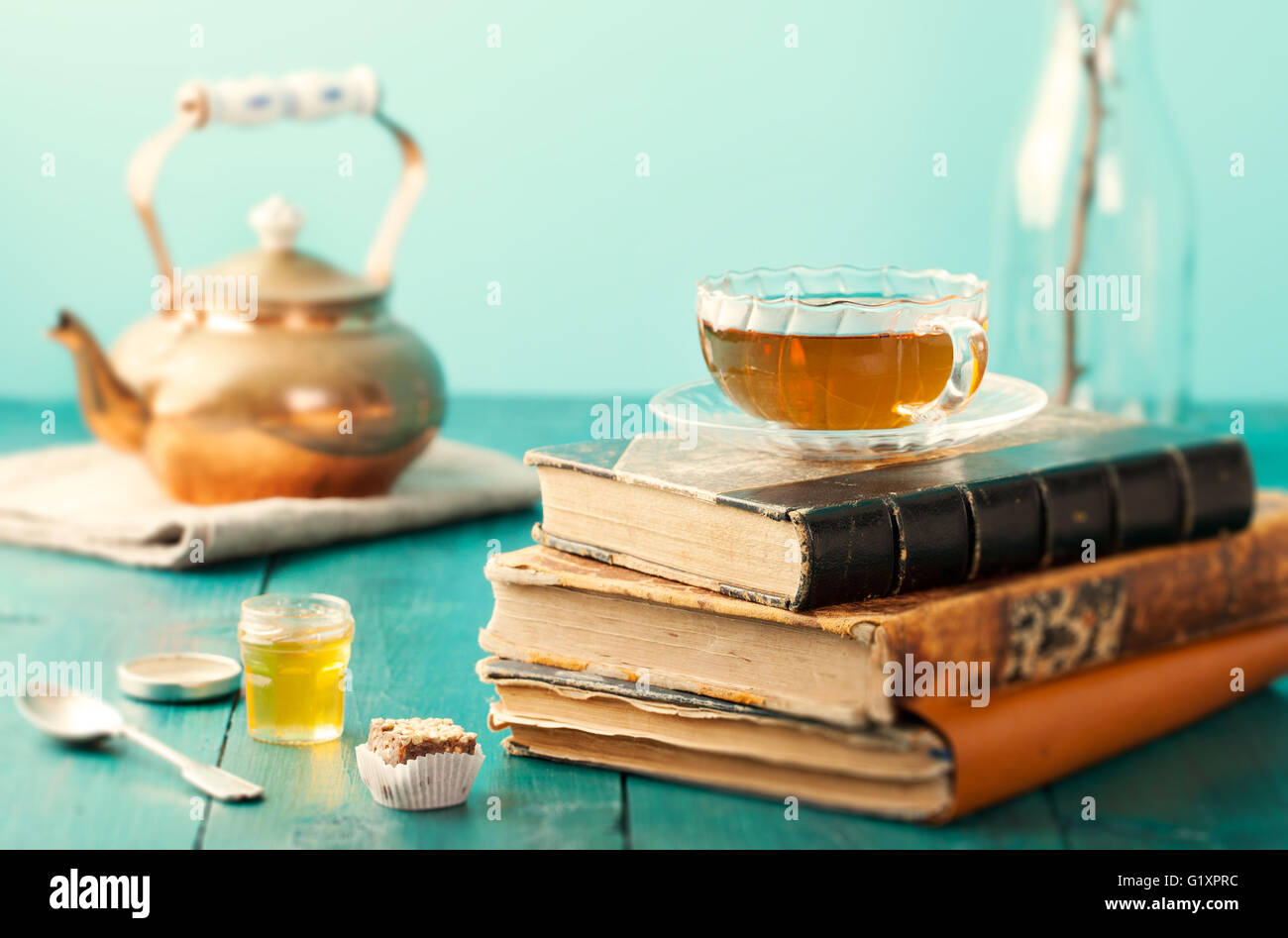 Cup of tea with teapot and vintage books on wooden table Stock Photo ...