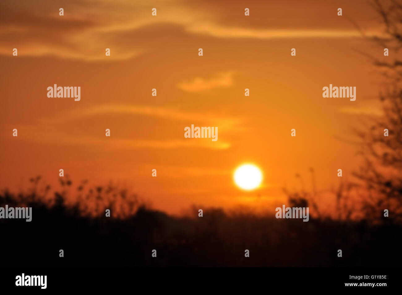 Blurred background image of a dramatic sunset in deep orange color over ...