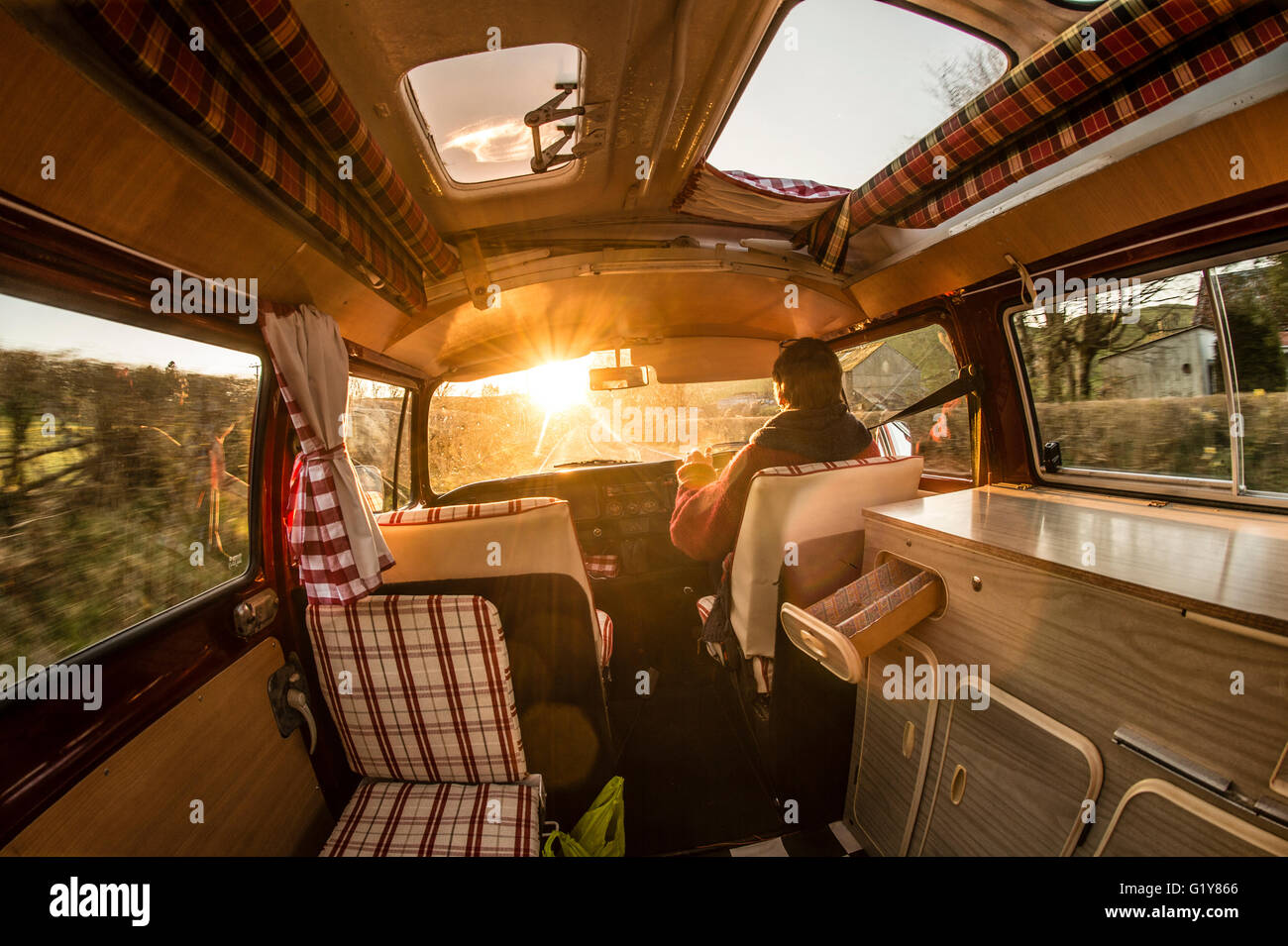 A woman driving her classic red 1972 Volkswagen VW T2 (type 2) camper ...