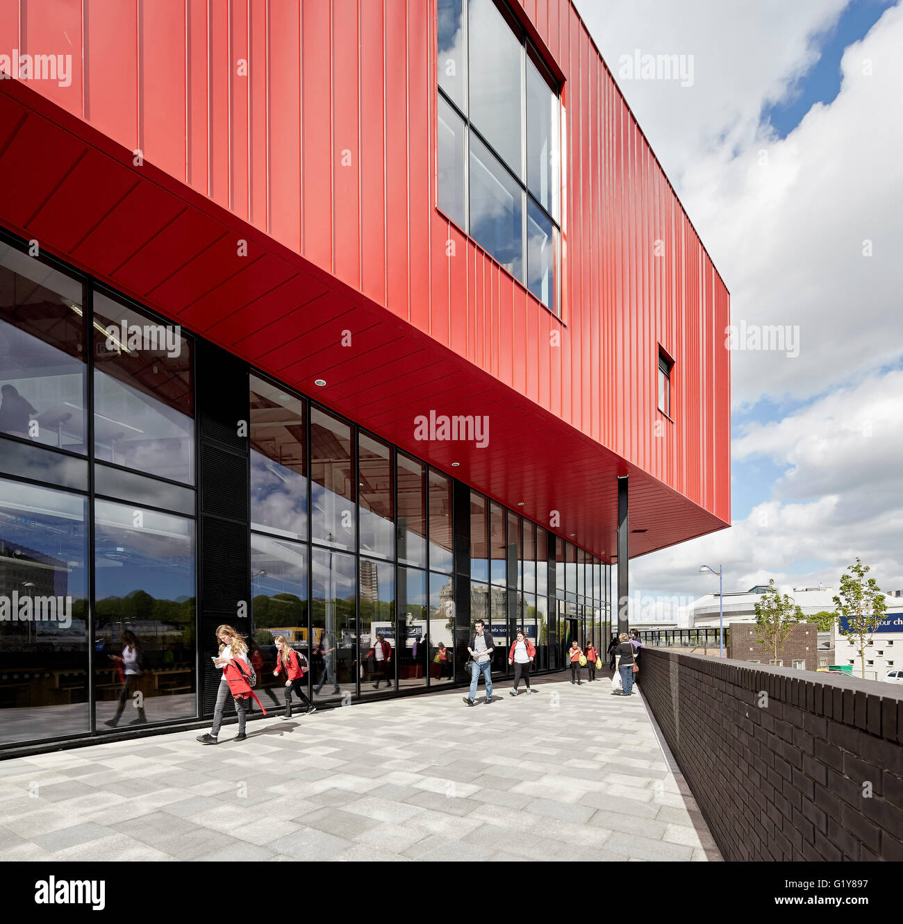 View along ground floor glazing and red steel cladding. Plymouth ...