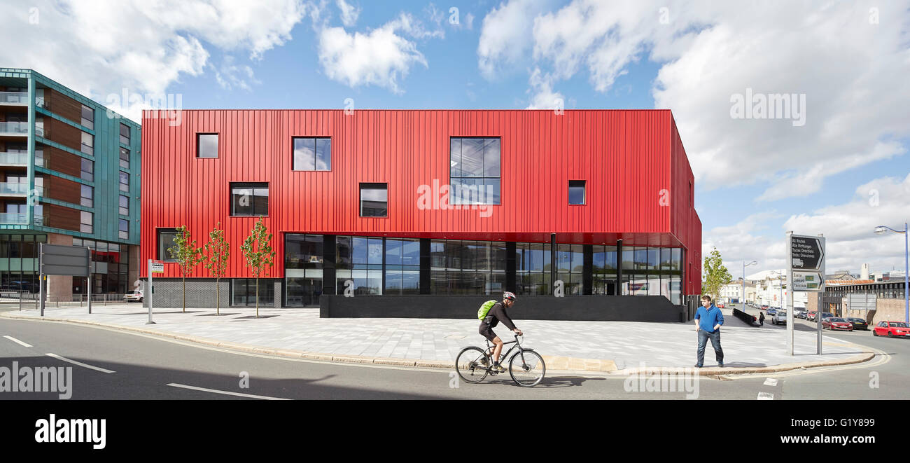 Front elevation of red facade with street, passerby and bicyclist ...