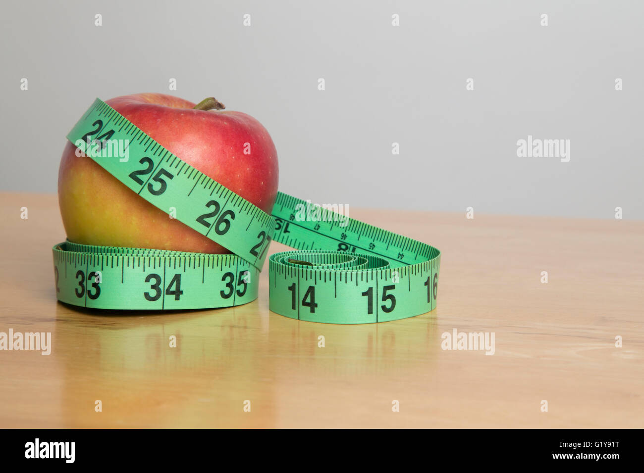Tape measure wrapped around apple Stock Photo - Alamy